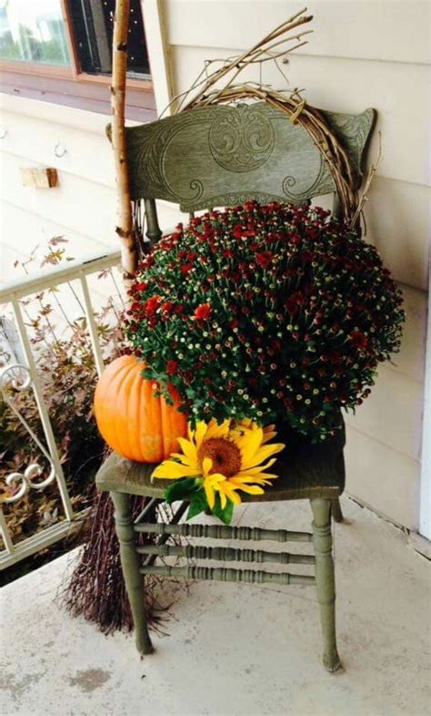 A Green Chair Sitting On Top Of A Porch Next To A Planter Filled With