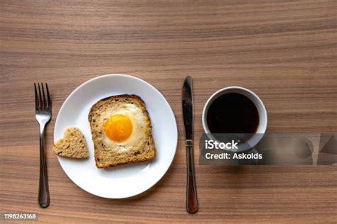 아침 식사 개념입니다 빵 구운 빵 달걀과 화이트 커피 컵의 마음을 가진 흰색 접시 나무 텍스처 배경입니다 갈색에 대한 스톡 사진