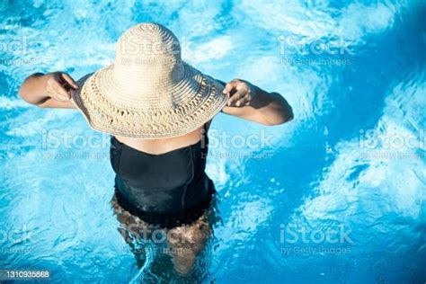 검은 색 수영복을 입은 커다란 밀짚 모자를 쓴 수영장에서 물 속에서 한 소녀 25 29세에 대한 스톡 사진 및 기타 이미지 25 29세 게으름 고여 있는 물 Istock