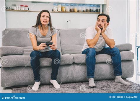La Esposa Juega Al Juego Mientras Que El Hombre Apenas Se Sienta Imagen