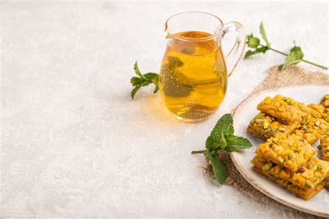Traditional Iranian Dessert Sohan With Glass Of Green Tea On A Gray