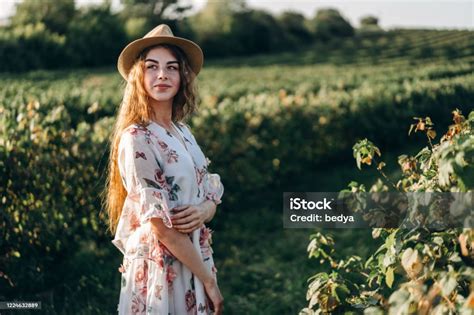 긴 곱슬 머리와 주근깨 얼굴과 아름다운 여자 건포도 필드 배경에 얼굴 여름 화창한 날에 가벼운 드레스를 입은 소녀가 걷는다 건강한 생활방식에 대한 스톡 사진 및 기타 이미지