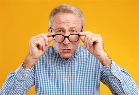 Mature Man Squinting Wearing Eyeglasses Looking At Camera Stock Image