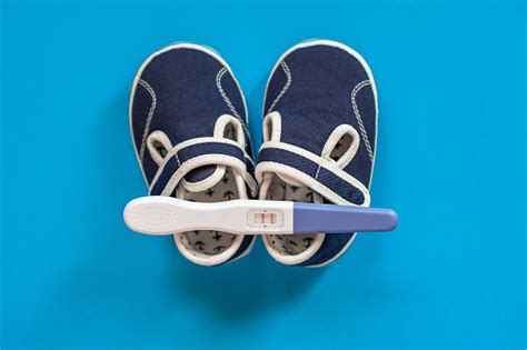 최소한의 플랫 아기 신발과 임신 테스트와 누워 임신 모성 출생의 개념 파란색 배경에 부츠와 긍정적 인 임신 테스트 가족에 대한 스톡 사진 및 기타 이미지 Istock