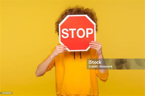 빨간 교통 표지판을 들고 정지 기호와 얼굴을 덮고 도시 스타일의 후드에서 익명의 사람의 초상화 가리기에 대한 스톡 사진 및 기타