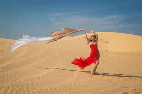 사막 속의 붉은 드레스를 입은 우아한 여성 · 무료 스톡 사진