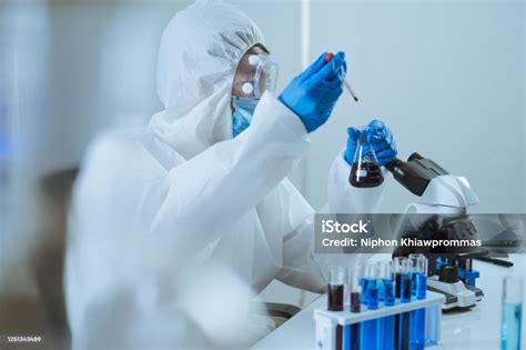 젊은 남자 과학자 드롭 하 고 혼합 하 고 실험실에서 찾고 에렌 마이어 플라스크에서 생화학을 흔들어 코로나 바이러스의 실험실