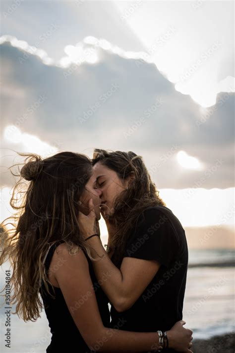 Pareja De Dos Chicas Morenas Jóvenes Que Son Novias Lesbianas Besándose En La Playa Junto Al Mar