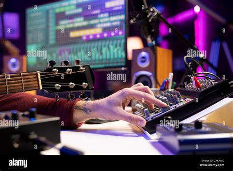 Sound Engineer Using Mixing Console And Acoustic Guitar In Home Studio