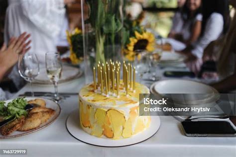 여름 테라스에서 생일 축하하는 가족 아름 다운 노란색 생일 케이크입니다 저녁을 먹는 사람들의 배경 야외에서 음식 개념 테이블에