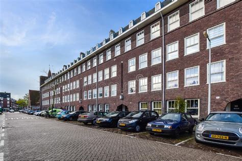 A Large Brick Building With Many Cars Parked In Front Editorial