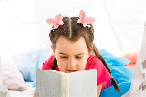 Appréciant La Grande Histoire Jolie Petite Fille Lisant Un Livre