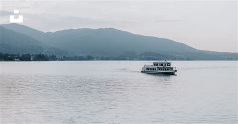 山に囲まれた白い船の写真 Unsplashの無料グレー写真