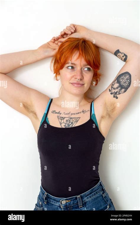 A Beautiful Woman In Her Mid Twenties With Tattoos And Unshaved Armpits With Her Arms Raised
