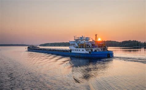 A Barge Floats On The Volga River Against The Background Of Sunset