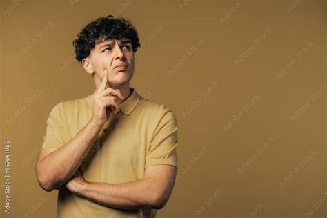Thinking Man Looking Up And Around On Yellow Background Worried