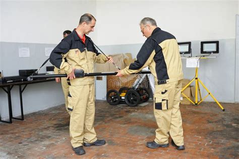 Radiation Detector Testing Two Dosimetrists Adjusting A Portable Gamma Radiation Dosimeter Set