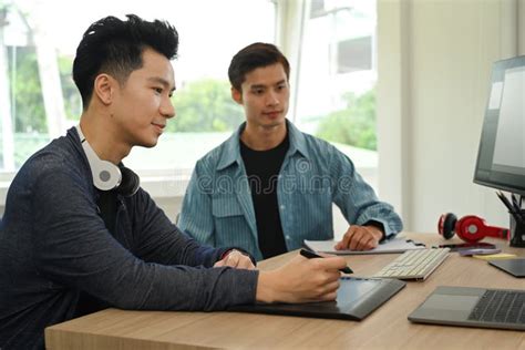 Two Young Content Creator Working Together Editing Video Footage With Professional Computer At