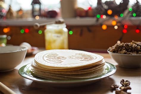 크리스마스 웨이퍼 녹색 접시는 창 옆에 나무 식탁에 배치 웨이퍼는 라운드 크림 색 재료에 둘러싸여 0명에 대한 스톡 사진 및 기타 이미지 Istock