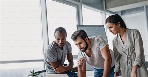 세 명의 다양한 사업가들이 사무실 회의실에서 일하는 동안 노트북을 통해 함께 이야기합니다 사무실에서 함께 비즈니스 프로젝트를 진행하는 비즈니스 팀 성공의 개념 사진