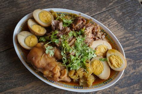 Thai Braised Pork Knuckle And Eggs With Spices And Vegetable On Wooden