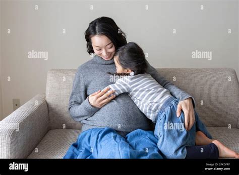 Girl hugging her pregnant mother Stock Photo - Alamy