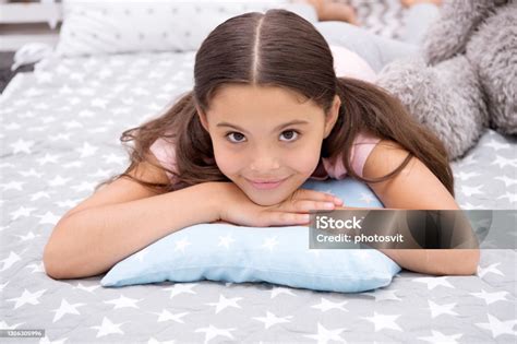 편안한 베개 행복한 아이를 미소 짓는 소녀는 스타 패턴 베개와 침실에 귀여운 격자 무늬가있는 침대에 누워 있었다 어린이를위한 침구 아침에 깨어난 소녀 아이 현대 유행 침구