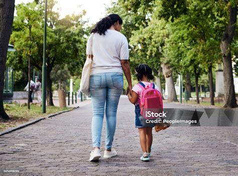 엄마 아이 배낭을 메고 손을 잡고 야외 공원에서 안전을 위해 학교로 걸어갑니다 어린 딸이나 딸이 안전한 여행 여행 또는 어린 시절 보살핌을 위해 함께 산책하는 엄마 걷기에