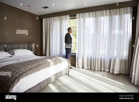 Man Standing By The Window In A Bedroom Stock Photo Alamy