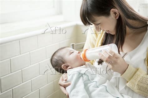 赤ちゃんにミルクを飲ませる母親 25497926 の写真素材 アフロ