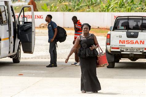 Unidentified Ghanaian Woman In Black Dress With Bag Walks In Lo