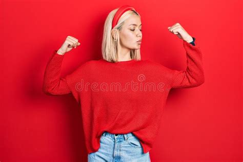 Beautiful Blonde Woman Wearing Casual Red Sweater Showing Arms Muscles