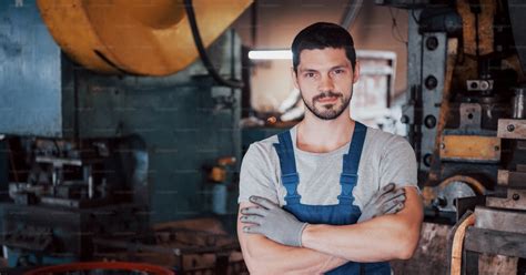 대형 폐기물 재활용 공장에서 안전모를 쓴 젊은 노동자의 초상화 엔지니어는 기계 및 기타 장비의 작업을 모니터링합니다 사진 Unsplash의 제조 이미지