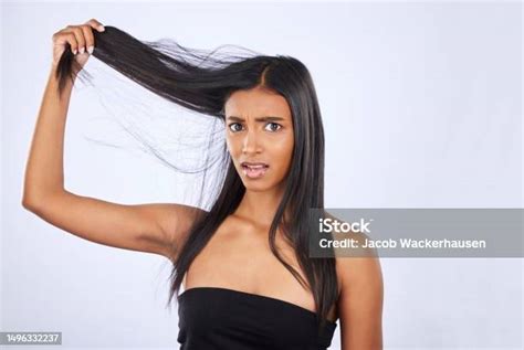 머리카락 손상 파손 및 스튜디오의 흰색 배경에 고립된 좌절한 여성의 초상화 나쁘고 불행하고 갈라진 끝 얽힌 헤어스타일 곱슬곱슬한 헤어케어에 대해 슬퍼하는 인도 소녀 20