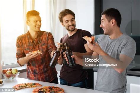 남자 맥주 마시는 고 부엌에서 피자를 먹는다 그들은 이야기 하 고 즐거운 시간 되세요 남자에 대한 스톡 사진 및 기타 이미지