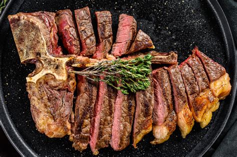얇게 썬 피렌체 스테이크 T 뼈 고기 쇠고기 검은 색 배경입니다 맨 위 보기 Steakhouse에 대한 스톡 사진 및 기타