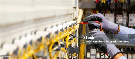 디지털 멀티 미터 측정 장비를 사용하여 주요 배전 기판에서 회로 차단기 및 케이블 배선 시스템에서 전류 전압을 검사하는 전기 엔지니어 Hfpa Installation