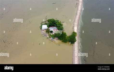 A High Angle Of Buildings Surrounded By Lush Trees And Mud Flats At A