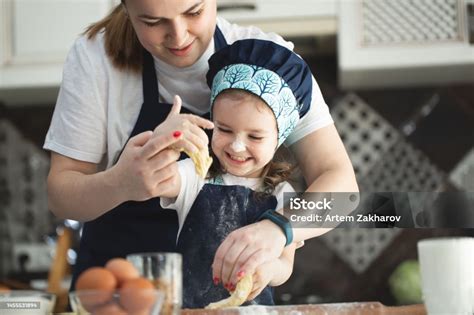 귀여운 작은 아이 딸이 현대 부엌에서 함께 그릇에 반죽을 준비하는 엄마 반죽을 돕는 2명에 대한 스톡 사진 및 기타 이미지