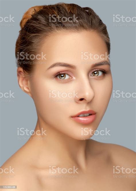 갈색 머리 아름다운 신선한 메이크업과 회색 배경에 건강한 깨끗한 피부를 가진 아름다운 여성의 초상화 메이크업 및 미용 개념 건강