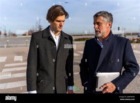 Concentrated Businessmen In Classy Outfits Standing On Street And