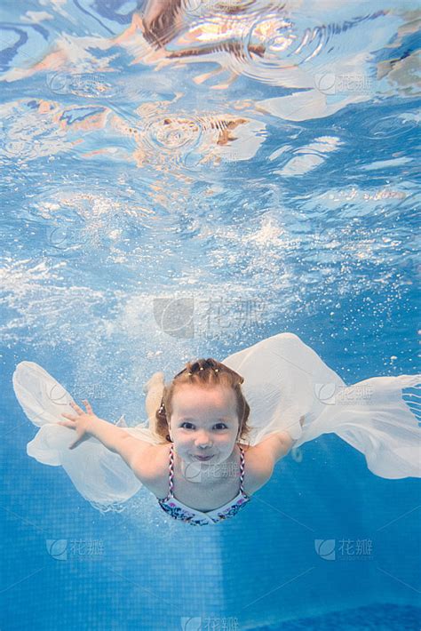 小女孩在戏水池里水下游泳。潜水。教孩子游泳。享受游泳和泡泡吧。