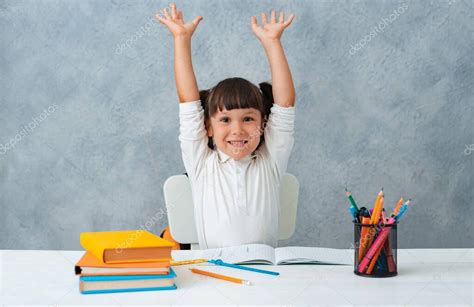De vuelta a la escuela Niña linda colegiala sentada en un escritorio