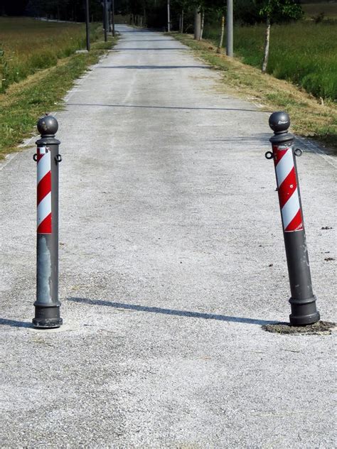 Old Small Columns Limiting A Public Pedestrian Road In The Green Fields