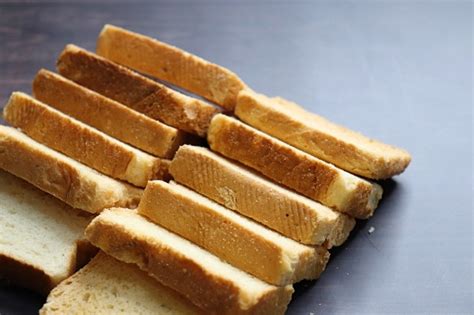 티타임 스낵 건강한 밀 러스크는 검은 색 배경 위에 인도의 뜨거운 마살라 차와 우유 주전자와 함께 제공됩니다 뭄바이 커팅