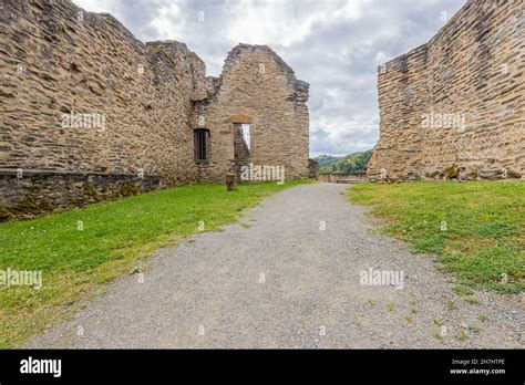 Dirt Path Between Green Grass And Deteriorated Stone Walls In The