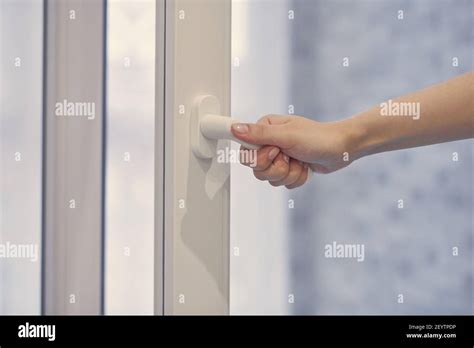 Woman Holding White Modern Handle At PVC Plastic Window With Double Glazing Opening And Closing