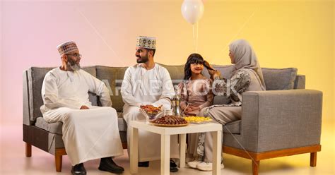 الجلوس في غرفة المعيشة في جو عائلي دافئ، ارتداء الثياب العمانية