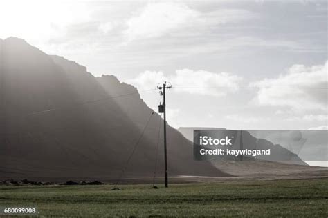 電線杆與日落在冰島陽光和陰影籠罩在風景上美麗的山脈在後面堅強的天性 照片檔及更多 光 照片 光 冒險 冰島 Istock