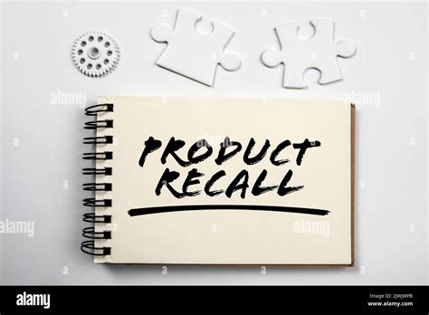 PRODUCT RECALL Notepad Puzzle Pieces And Gear On White Office Table
